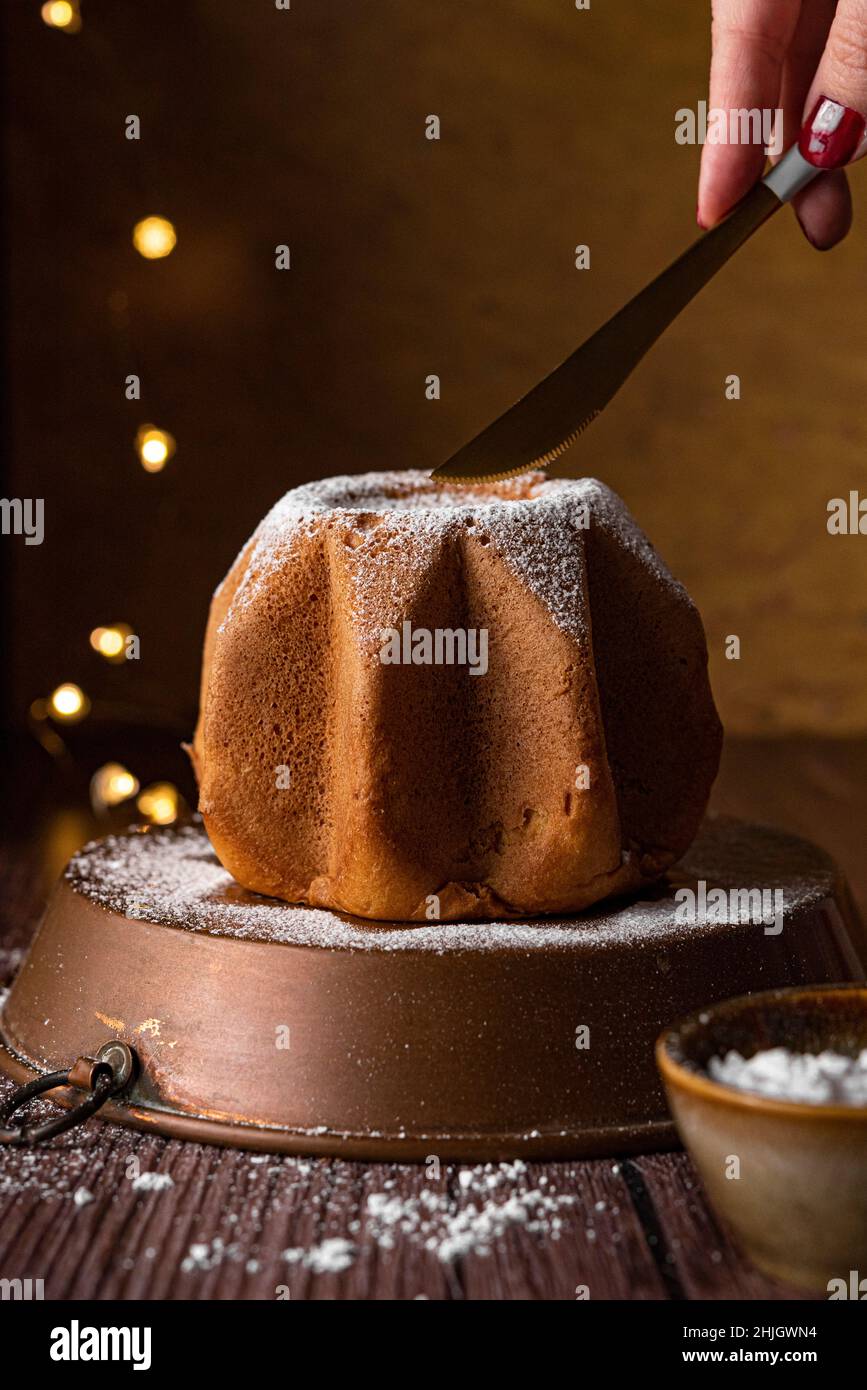 Hand cutting a small pandoro Stock Photo - Alamy