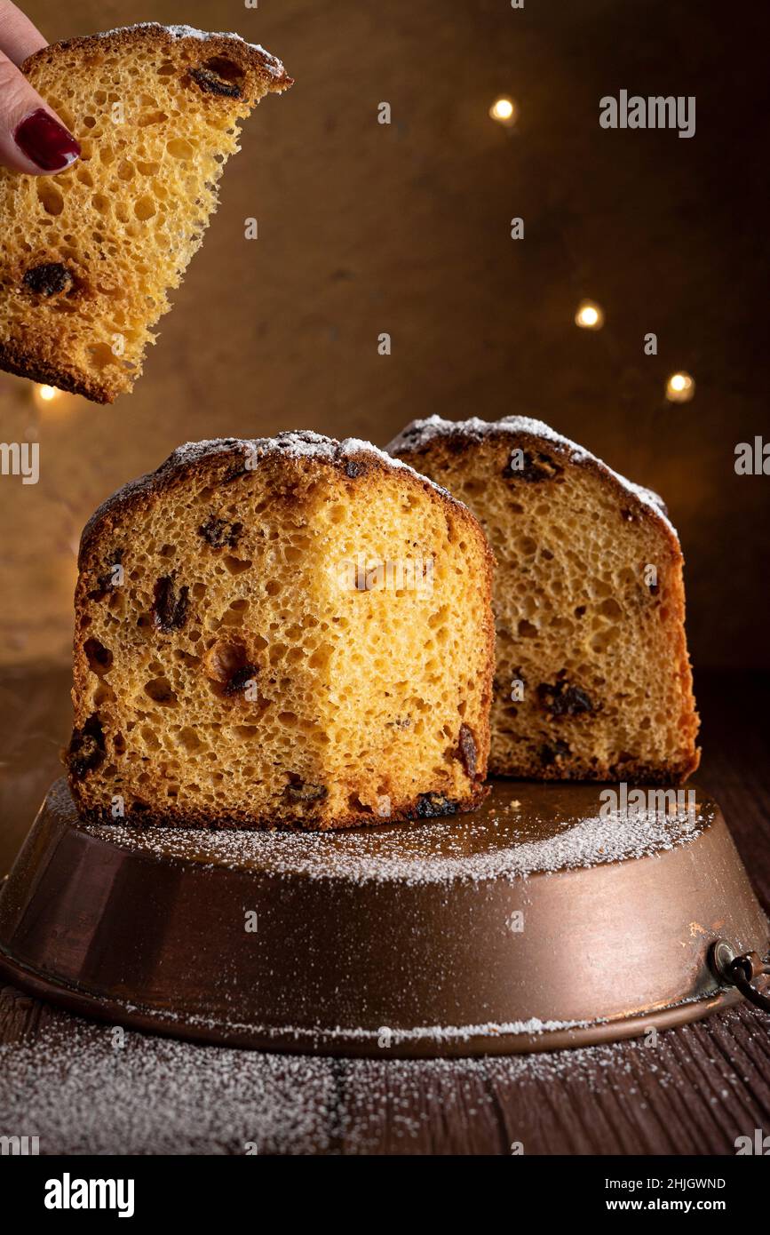 Hand holding a slice of panettone Stock Photo - Alamy