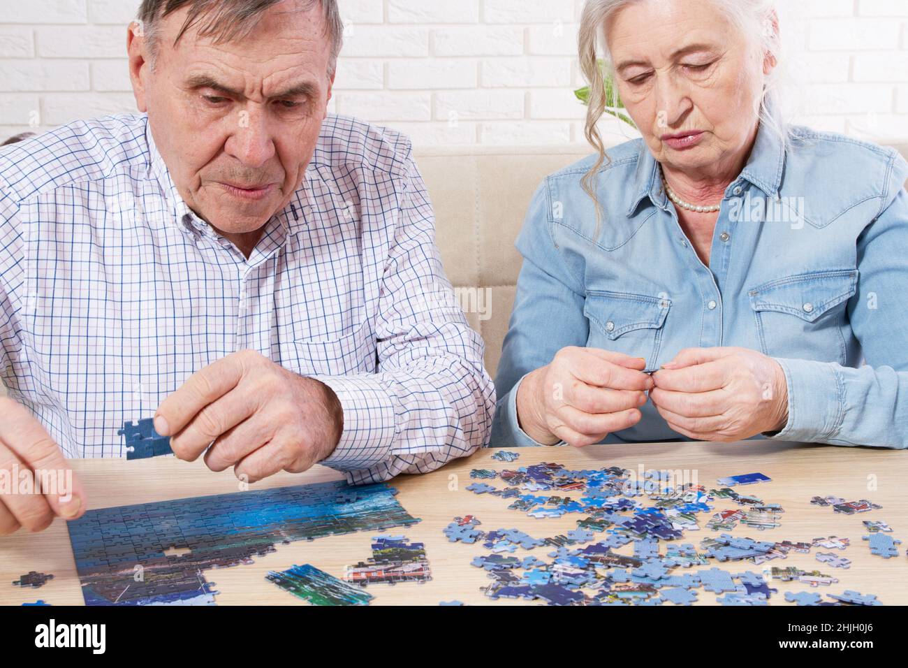 Elderly couple collecting puzzles at home, old couple play jigsaw Stock ...