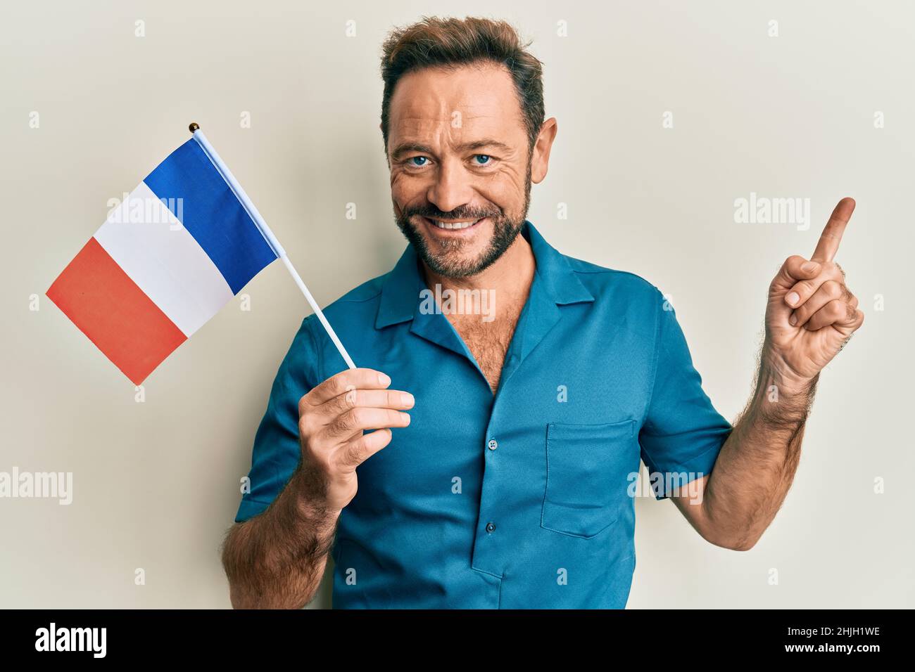Middle age man holding france flag smiling happy pointing with hand and ...