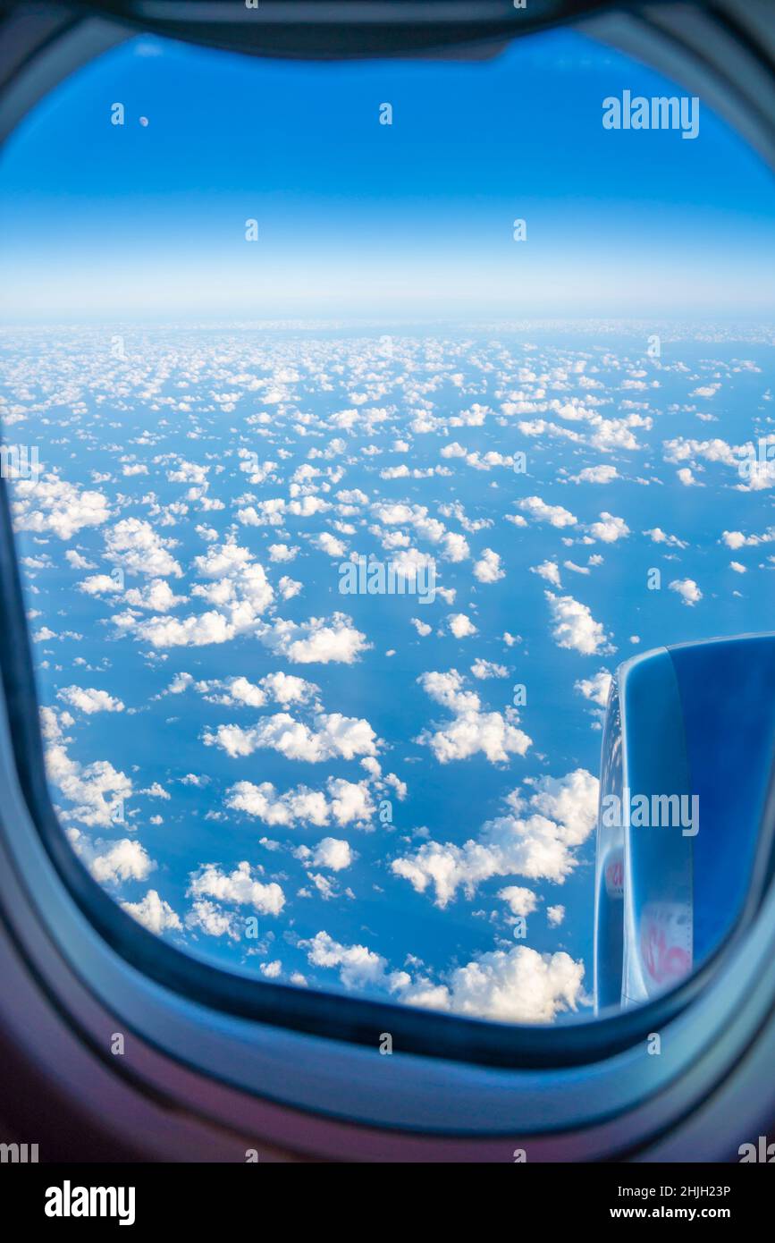 View of airplane engine and clouds over the sea through window ...