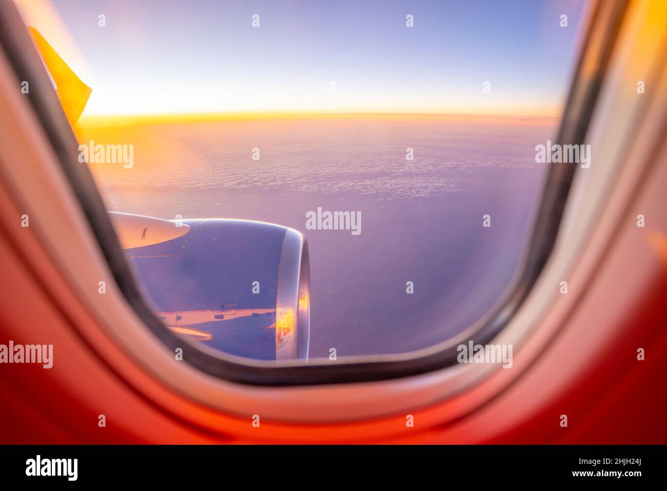 View of airplane engine and clouds over the sea at sunset through ...