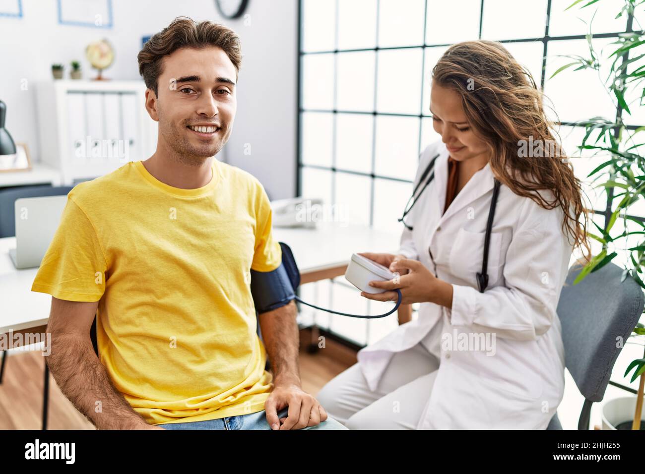 Young doctor woman checking blood pressure on patient looking positive ...