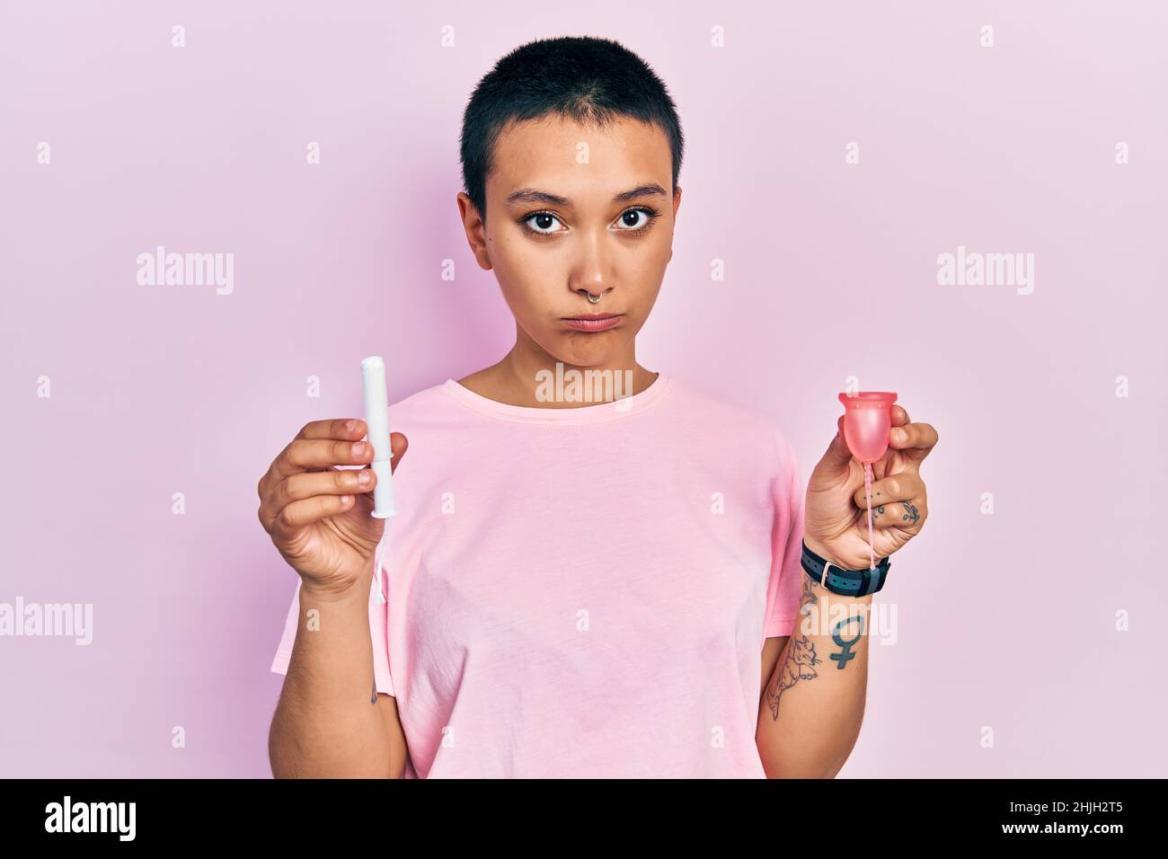 Beautiful hispanic woman with short hair holding menstrual cup and ...