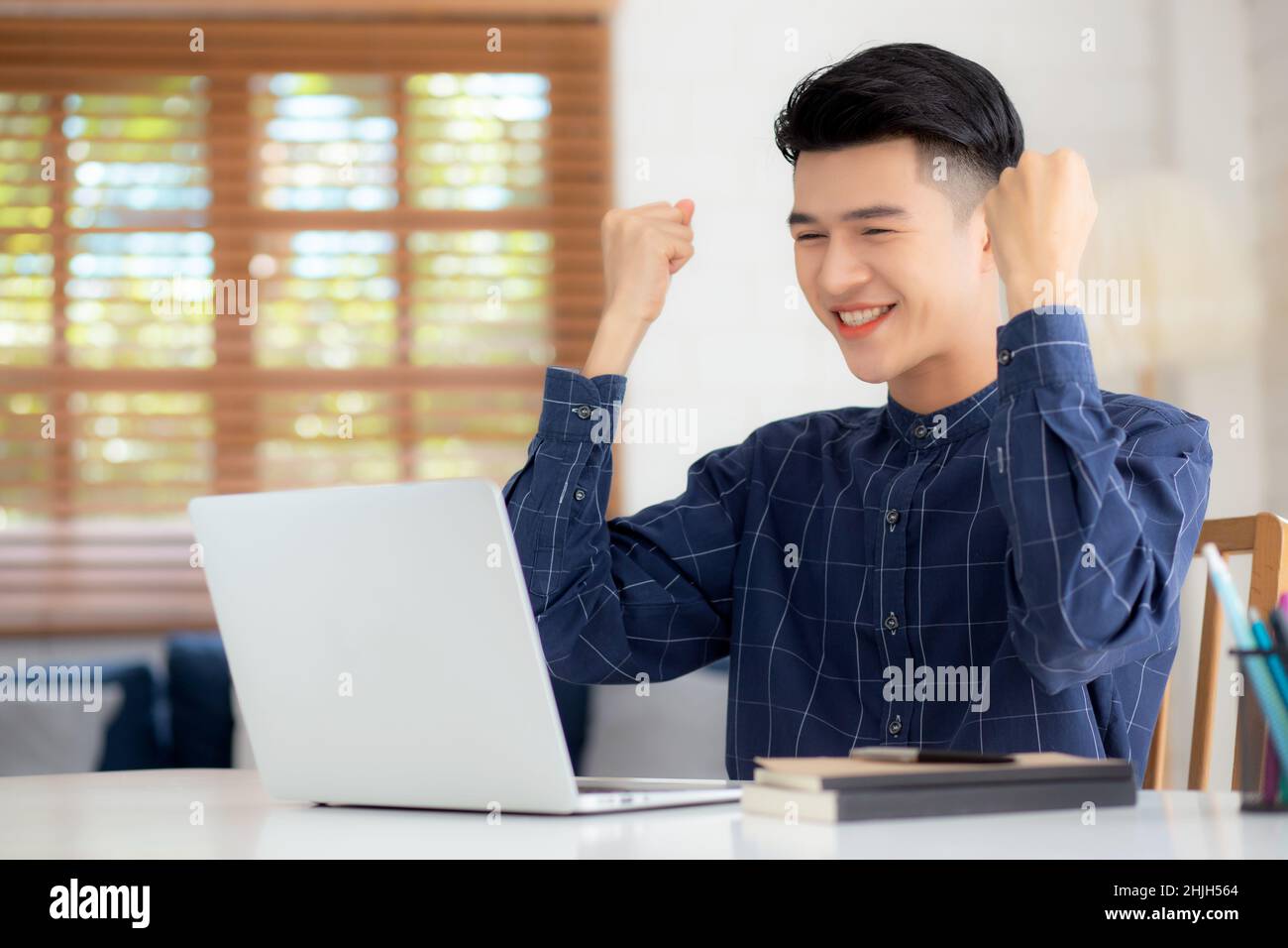 Happy young businessman work on laptop computer finish with excited and ...