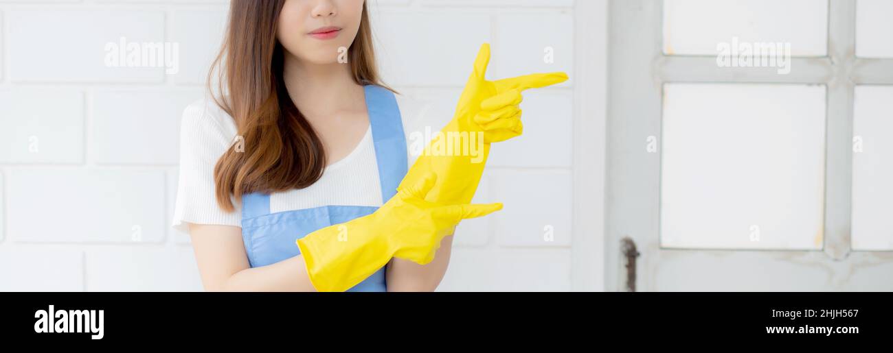 Portrait young asian woman is housekeeper in rubber gloves and apron ...