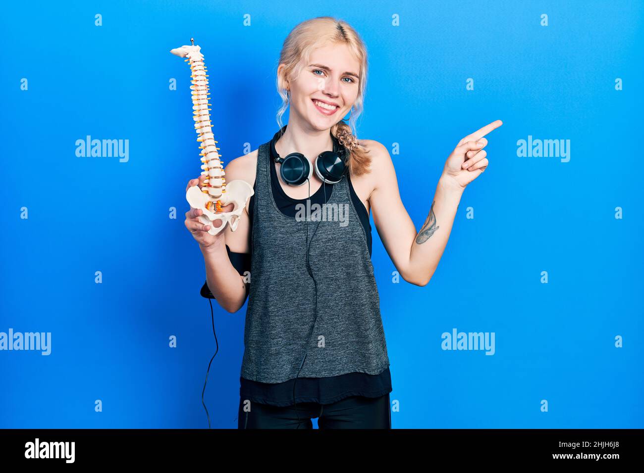 Beautiful caucasian sports woman with blond hair holding anatomical ...