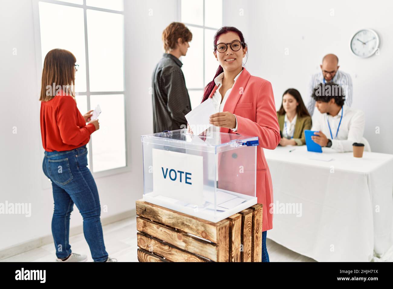 Young voter woman smiling happy putting vote in voting box at electoral ...