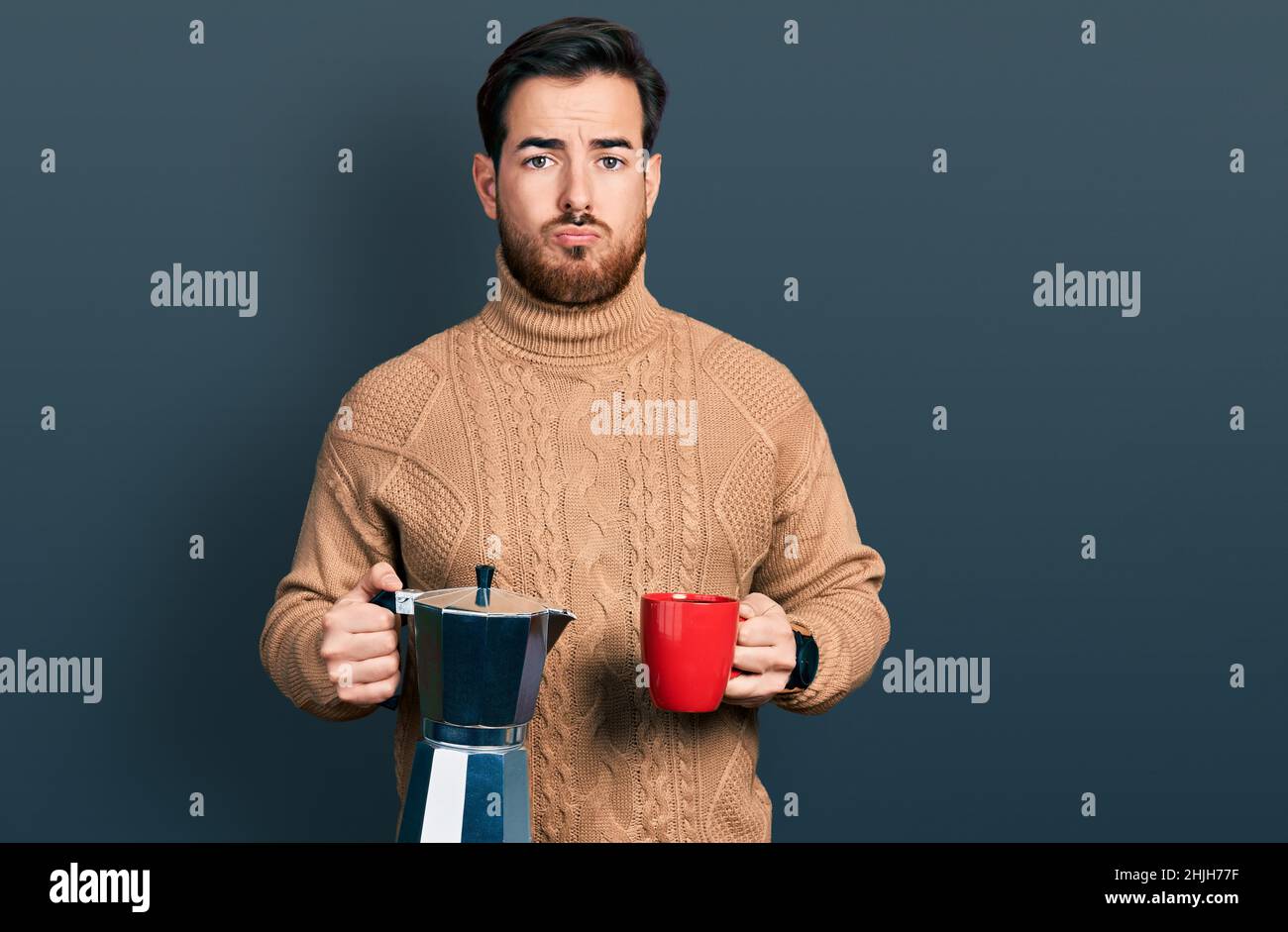 Young hispanic man drinking italian coffee depressed and worry for ...