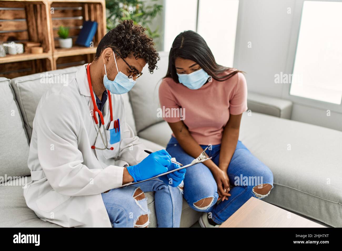 Young doctor man reading patient checklist report sitting on the sofa ...