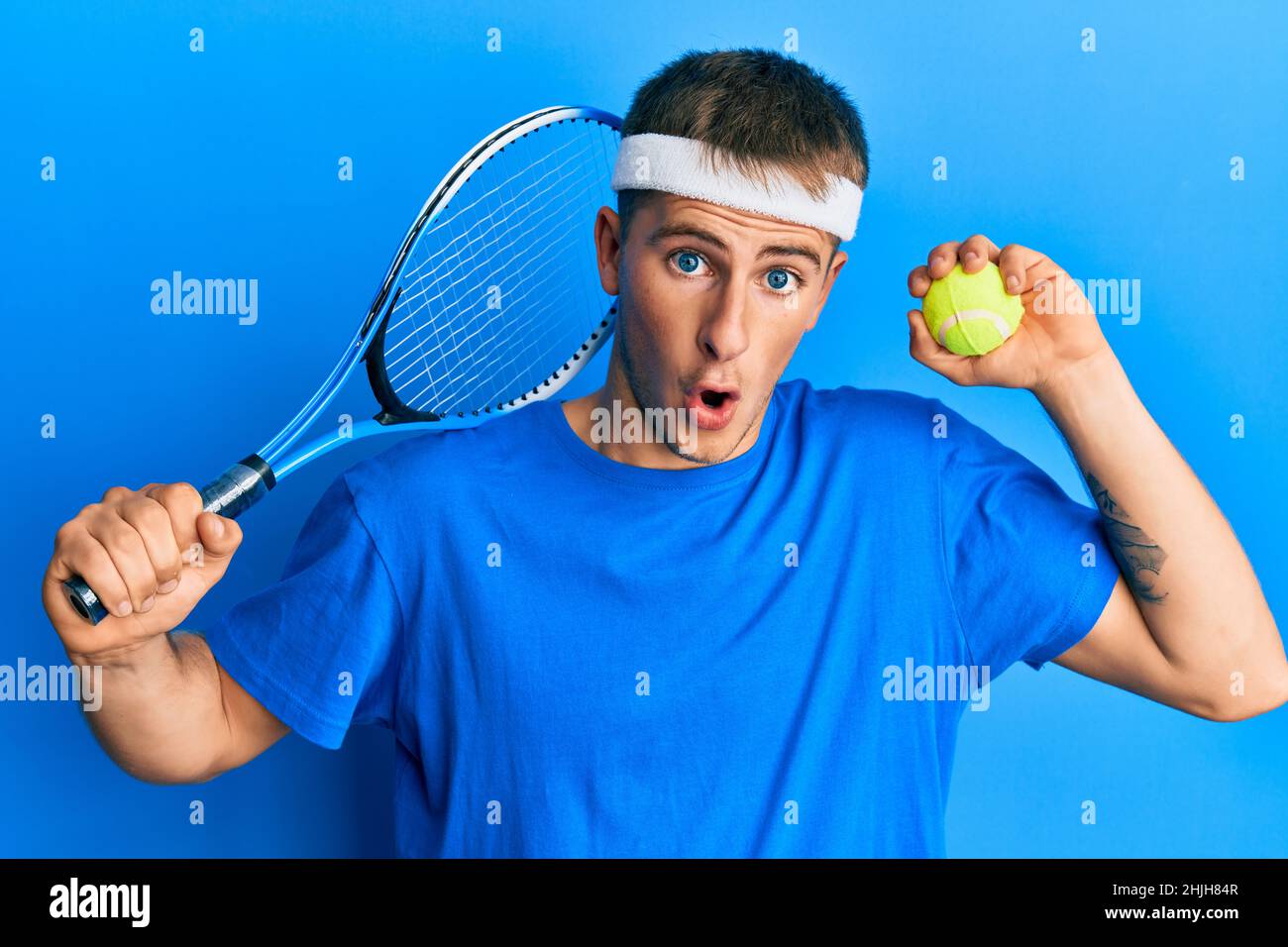 Young caucasian man playing tennis holding racket and ball afraid and ...