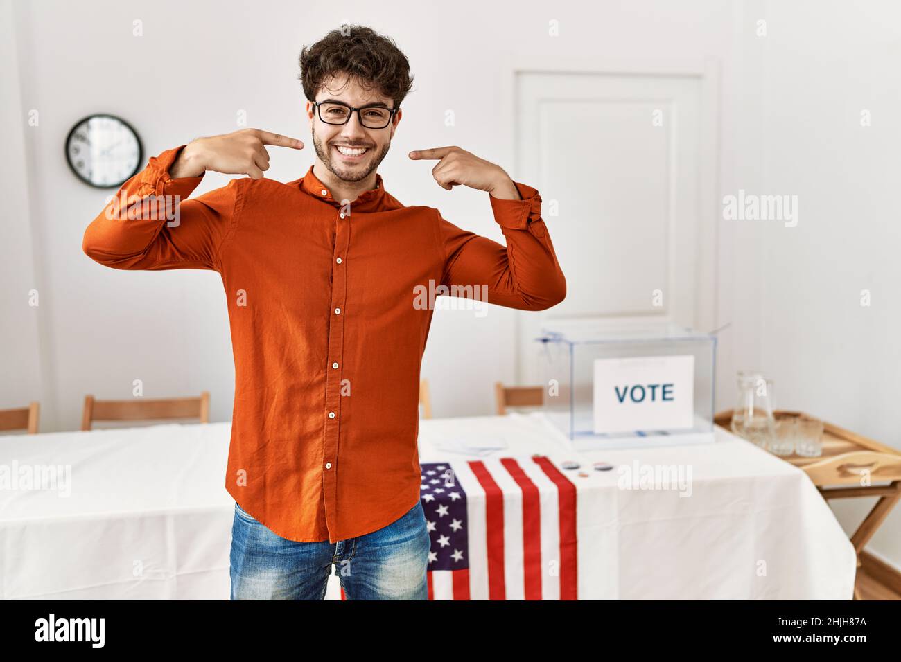 Hispanic man standing by election room smiling cheerful showing and ...