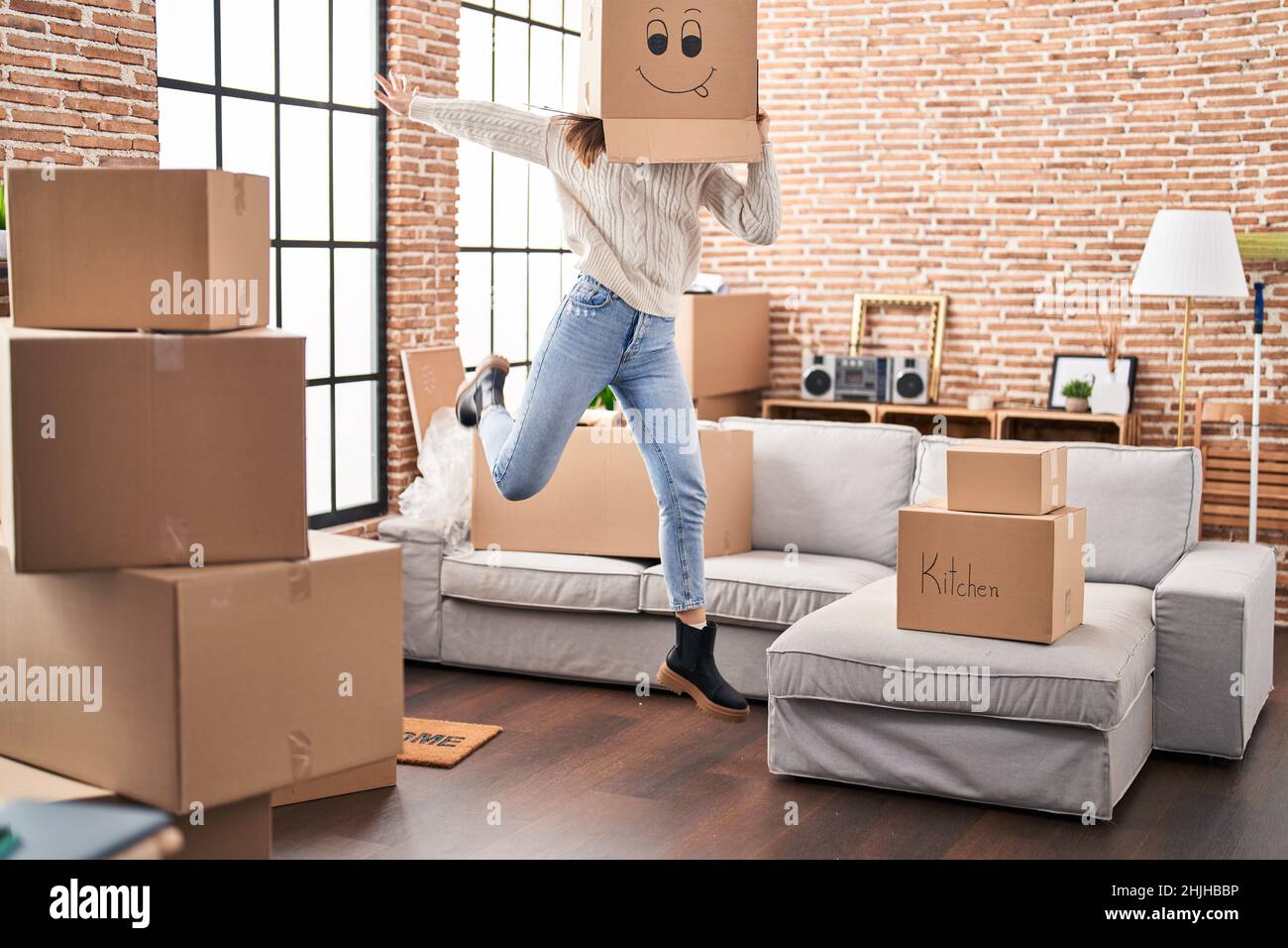Young woman dancing with funny cardboard box on head at new home Stock ...
