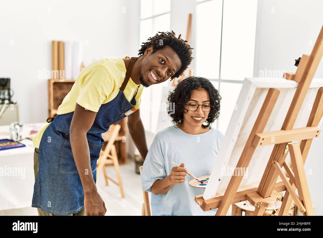 African american artist couple smiling happy painting at art studio ...