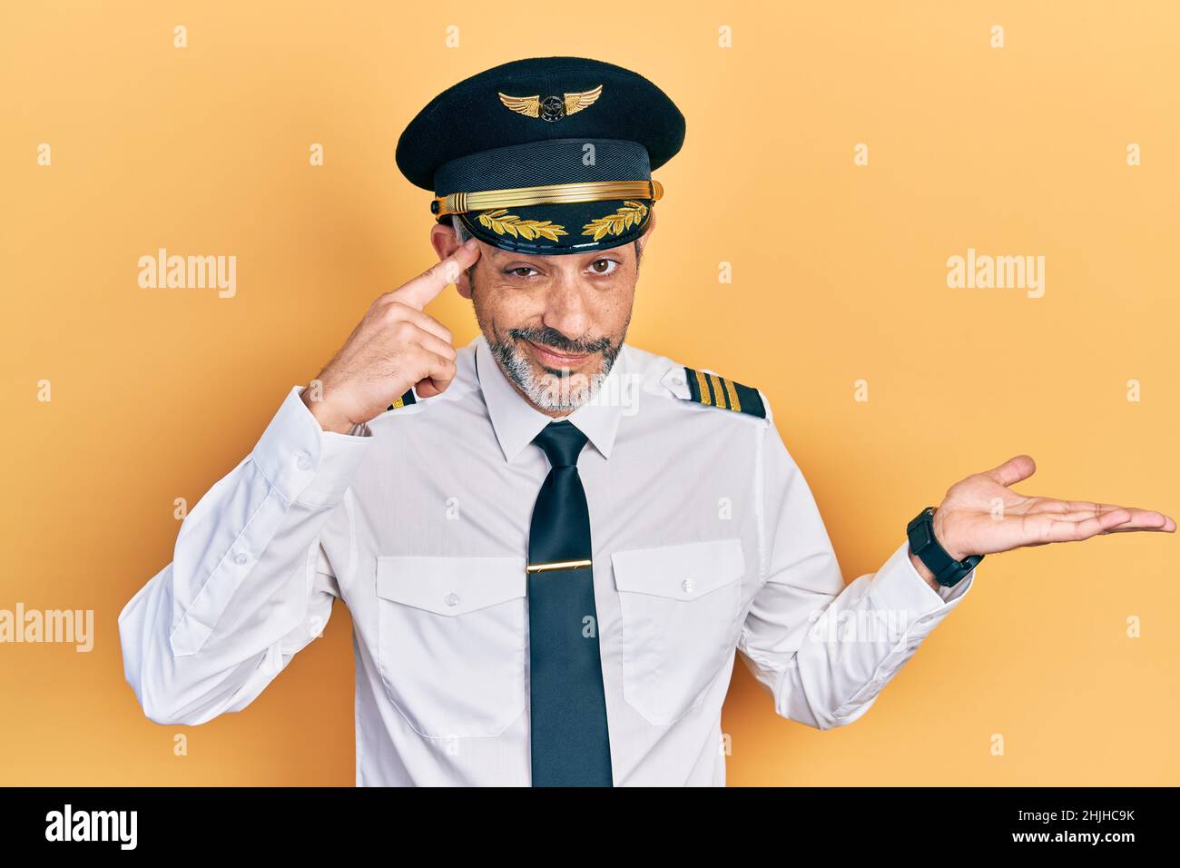 Handsome middle age man with grey hair wearing airplane pilot uniform ...