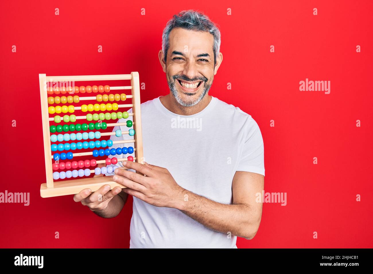 Handsome middle age man with grey hair holding traditional abacus ...
