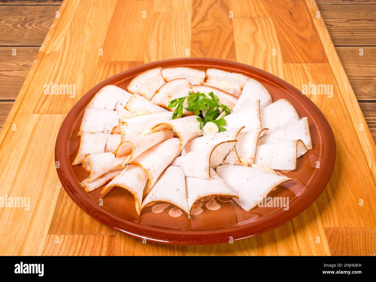 Delicious salted pork fat with parsley. Plate located on wooden table ...