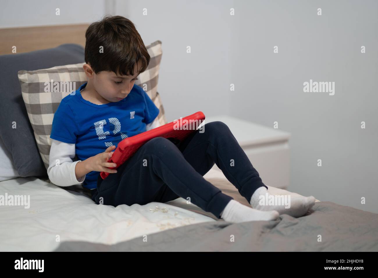 Boy Child playing with electronics tablet - alone during quarantine ...