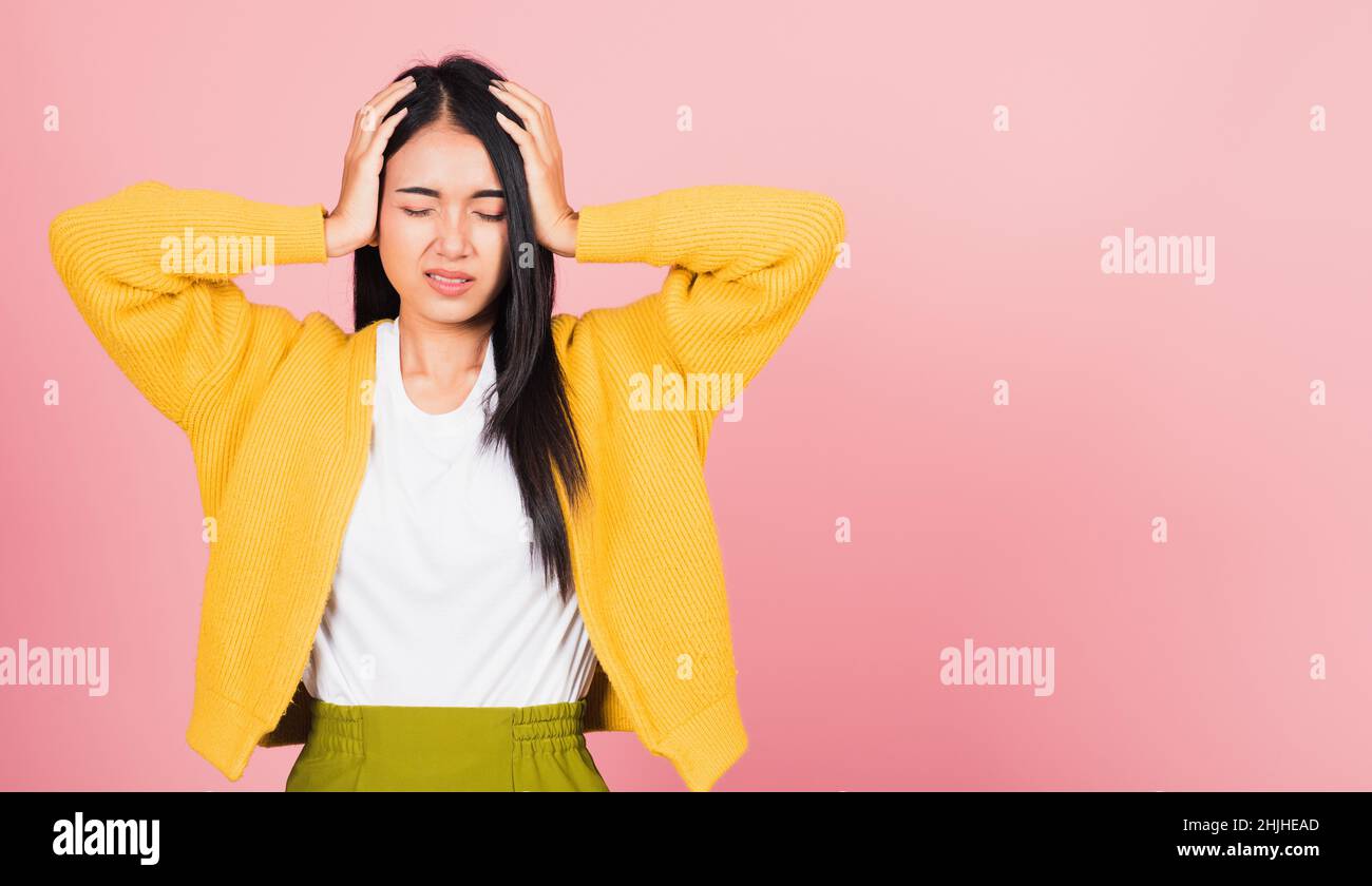 Portrait of beautiful Asian young woman sad tired strain face holding ...