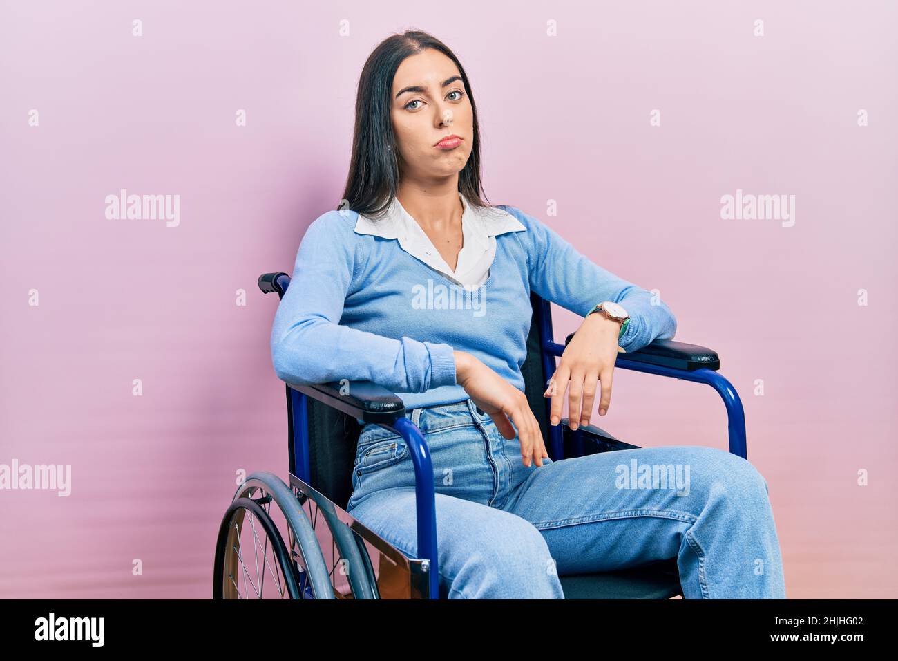 Beautiful woman with blue eyes sitting on wheelchair depressed and ...