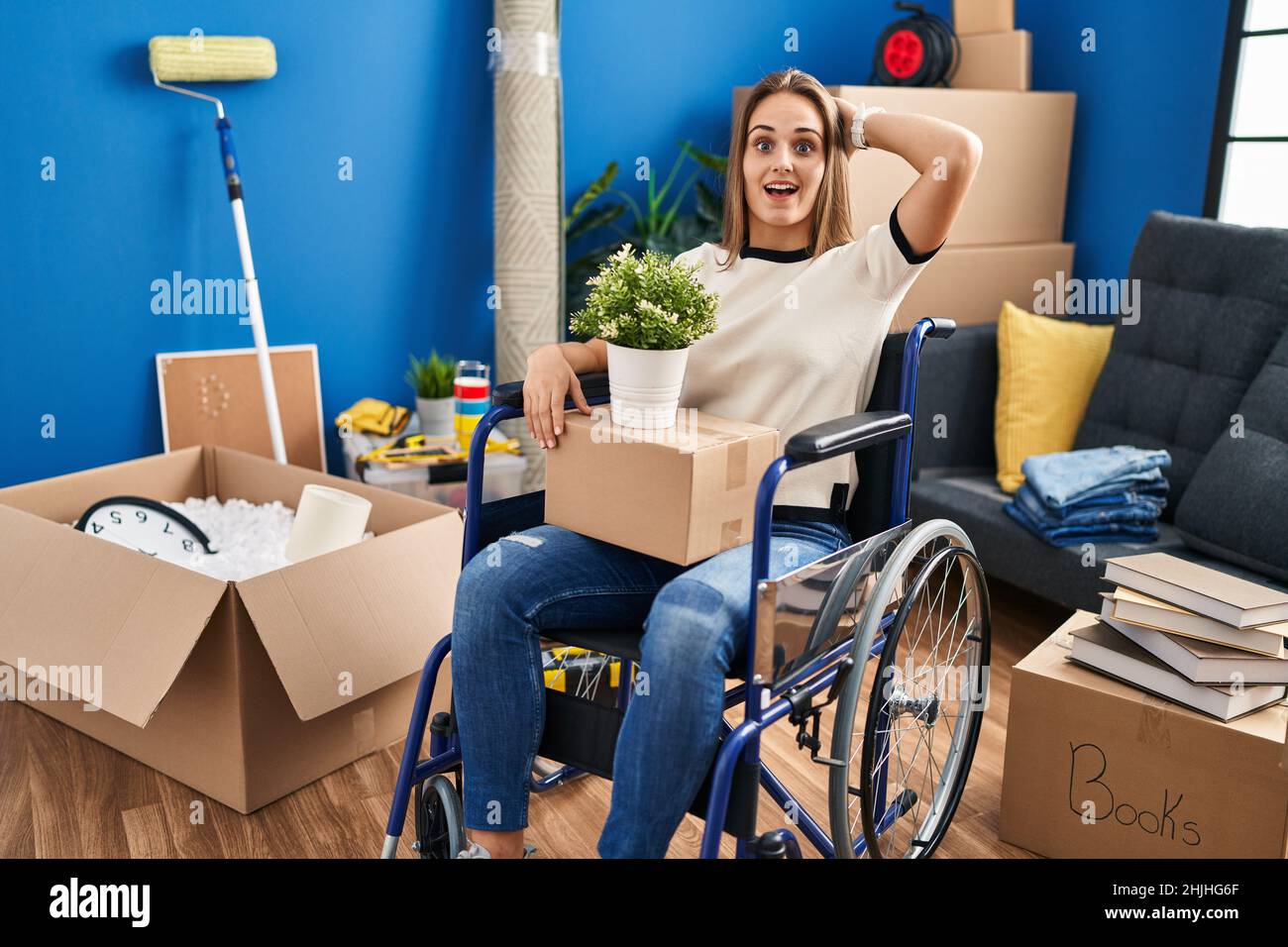Young woman sitting on wheelchair moving to a new home crazy and scared ...