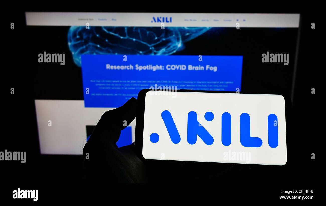 Person holding mobile phone with logo of US biotech company Akili ...