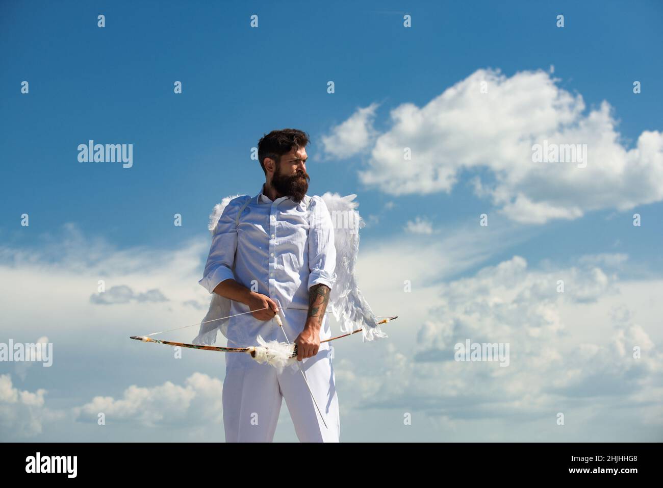 Funny cupid, handsome guy on valentine day with bow arrow shooting ...