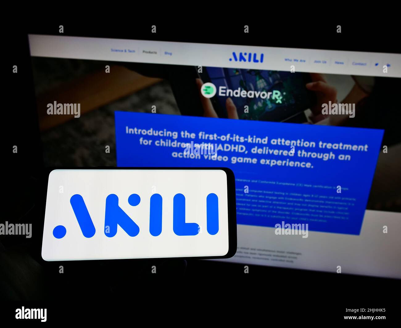 Person holding cellphone with logo of American biotech company Akili ...