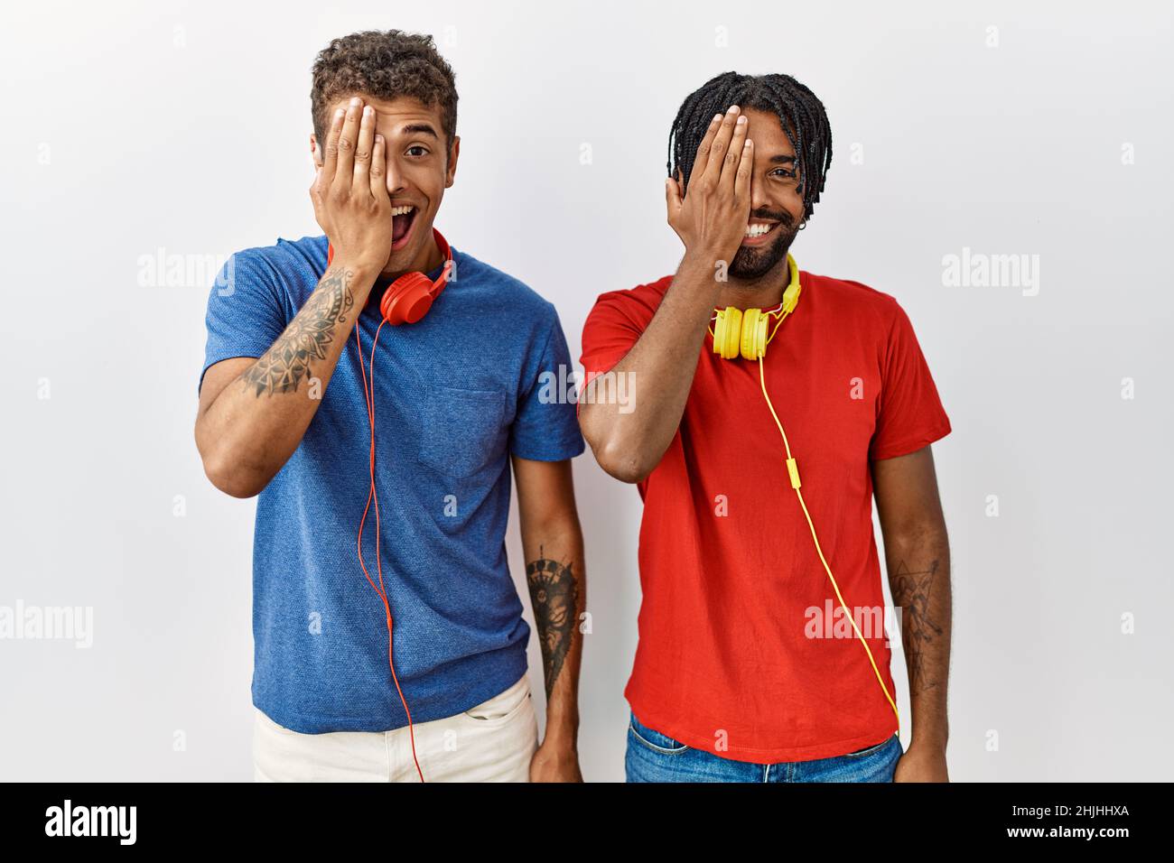 Young hispanic brothers standing over isolated background wearing ...