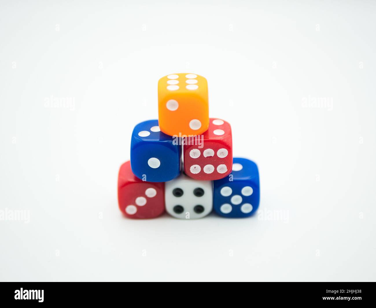 Mixed color of dice arranged in pyramid tower isolated on white ...