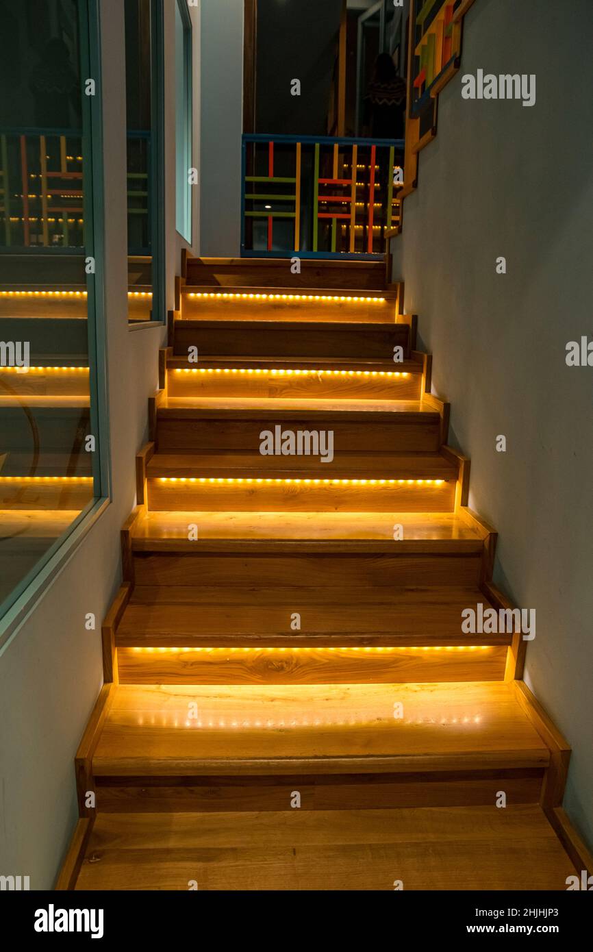 Illuminated staircase with wooden steps and illuminated at night in the ...