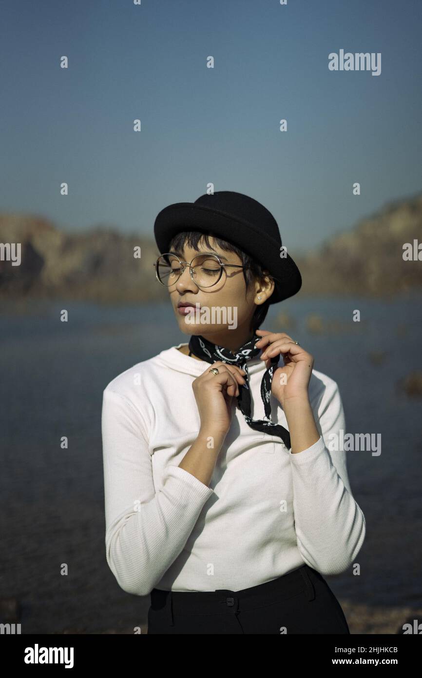 Vertical of an artistic Indian female wearing a white sweater with a ...