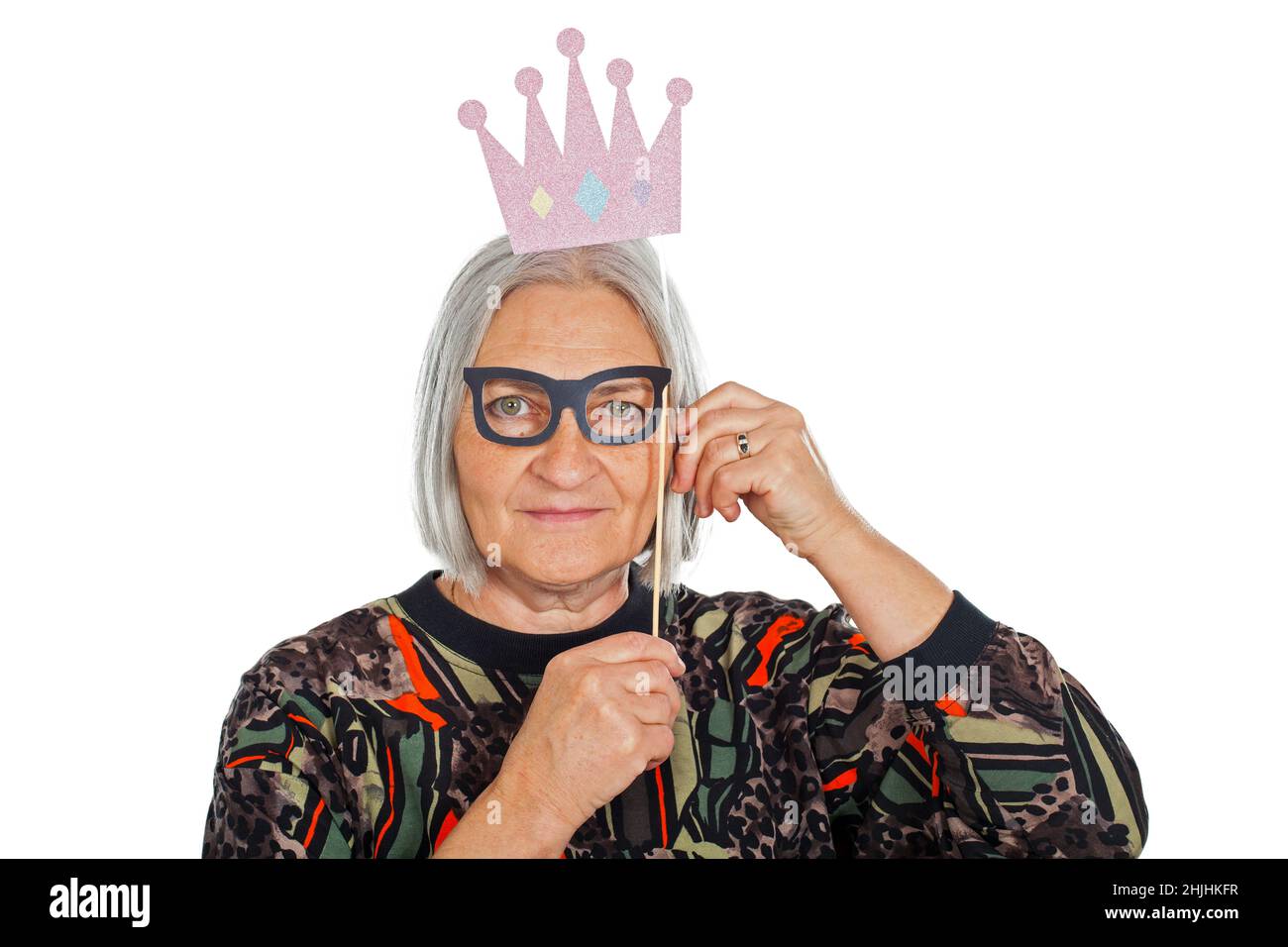 Elderly woman having fun with photo booth accessories on isolated ...