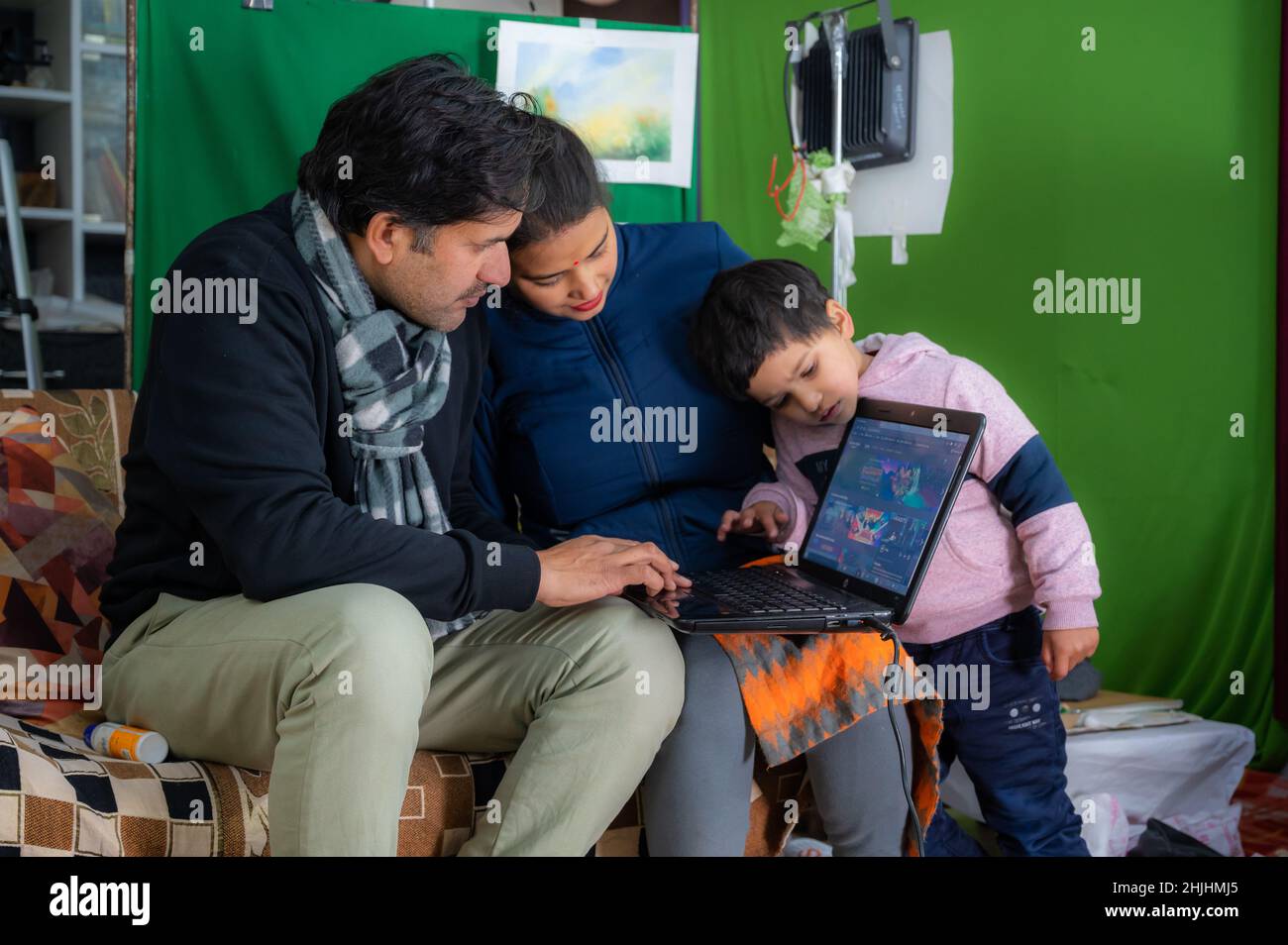 parents teaching their child to study with a laptop and come and ...