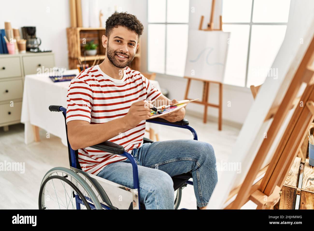 Young arab disabled artist man drawing sitting on wheelchair at art ...