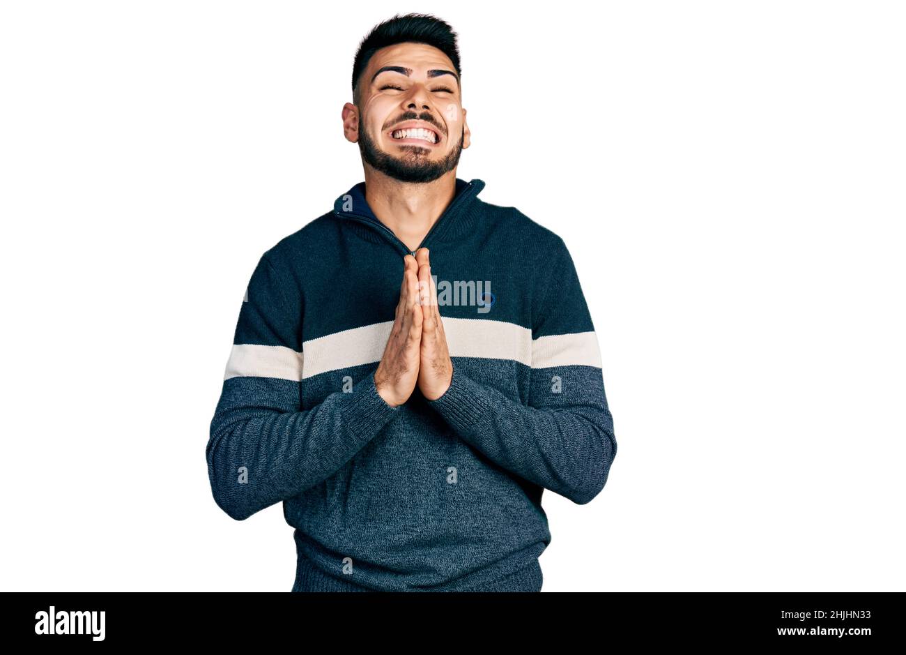Young hispanic man with beard wearing casual winter sweater begging and ...
