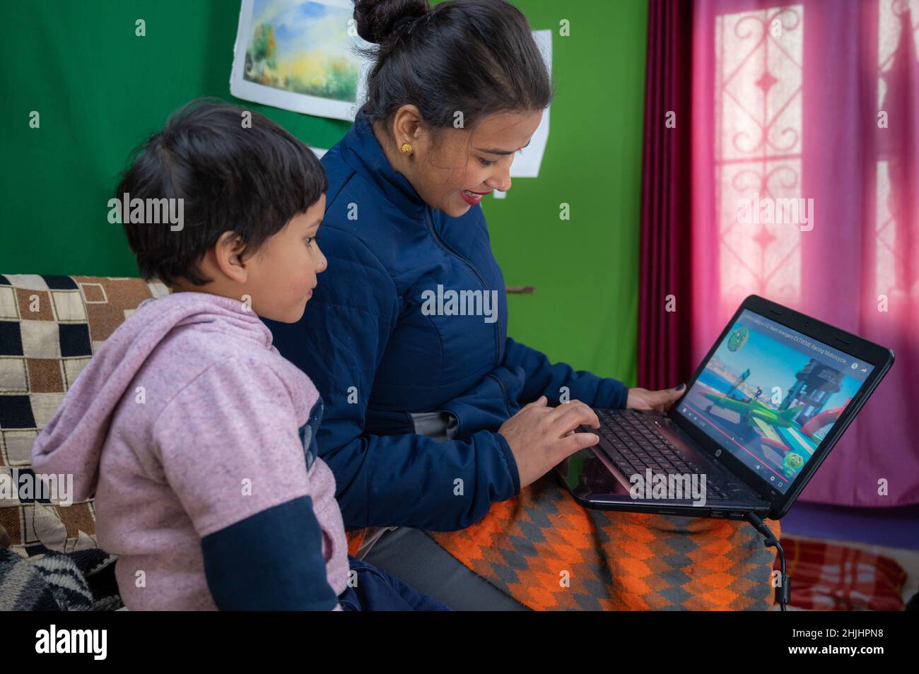 mom teaching their child to study with a laptop and come and operated a ...