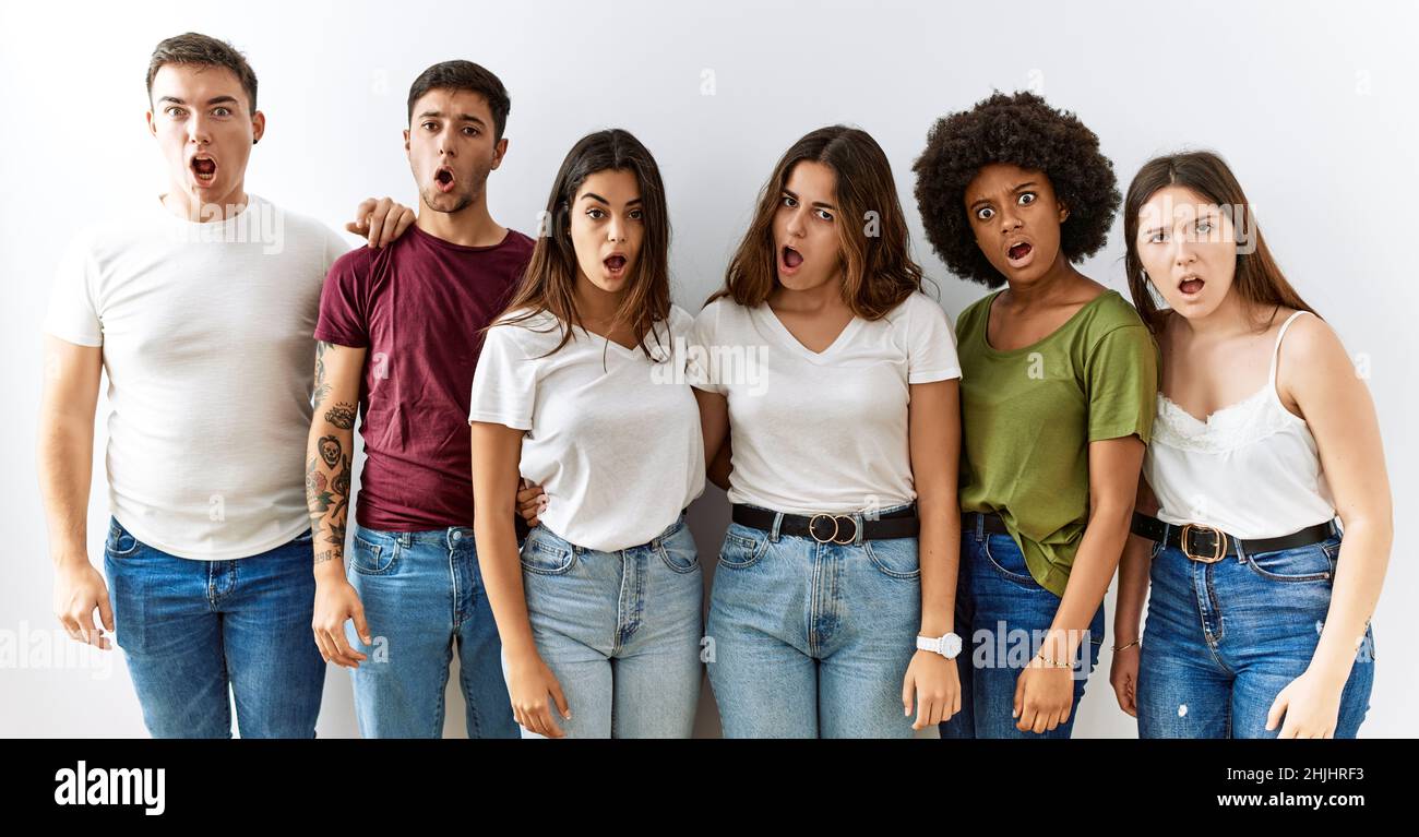 Group of young friends standing together over isolated background in ...
