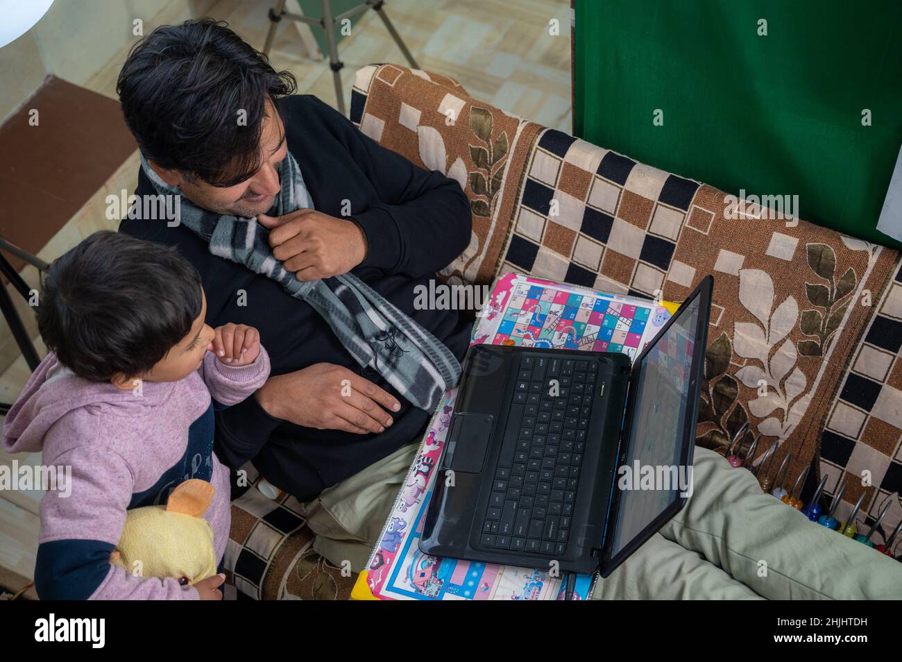 father teaching their child to study with a laptop and come and ...