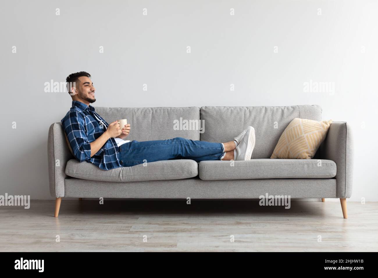 Man having rest at home on the couch, drinking coffee Stock Photo - Alamy
