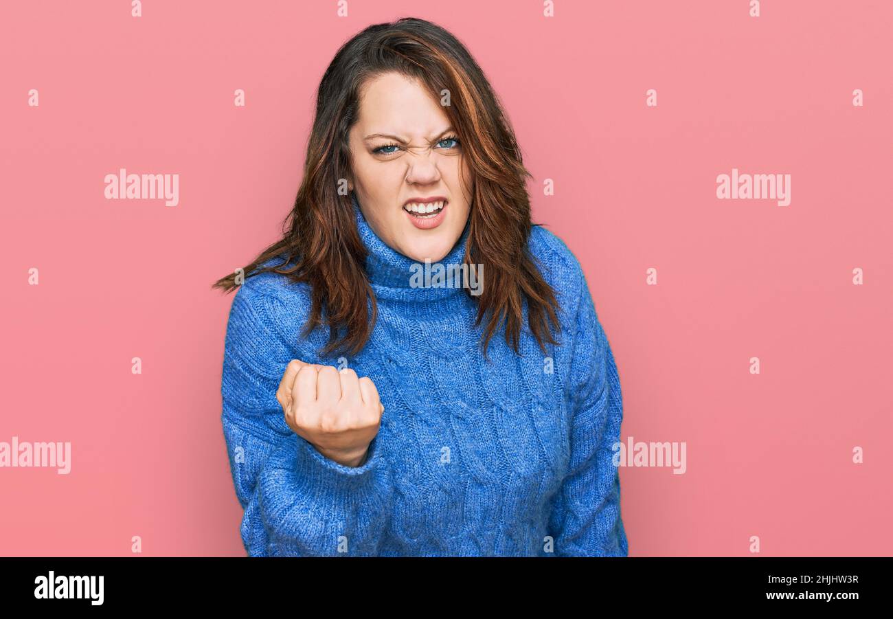 Young plus size woman wearing casual clothes angry and mad raising fist ...