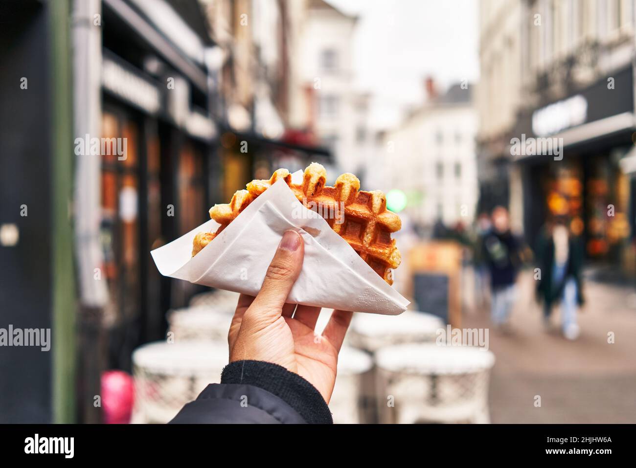 Hand of man holding waffle at street Stock Photo - Alamy
