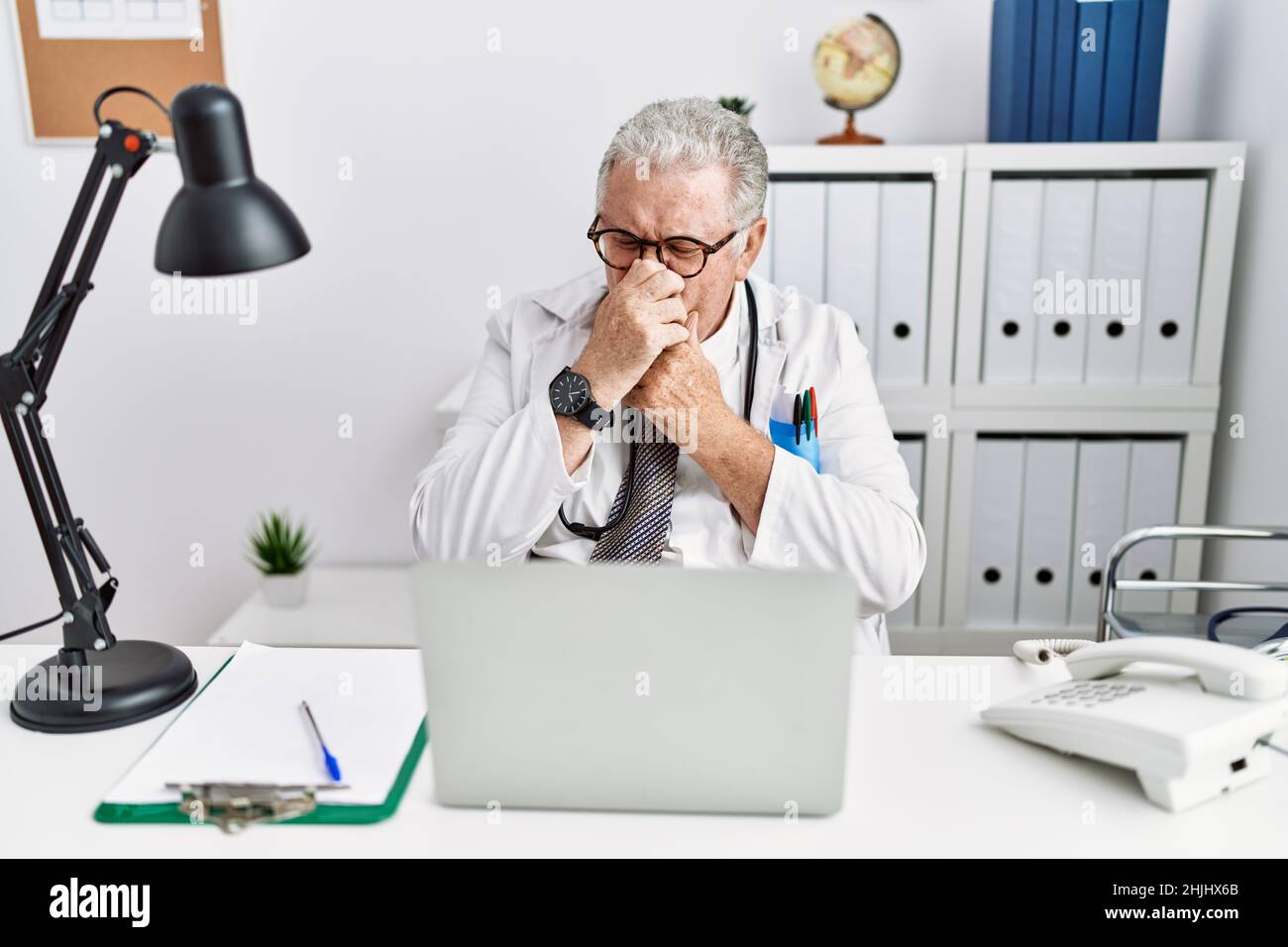 Senior caucasian man wearing doctor uniform and stethoscope at the ...