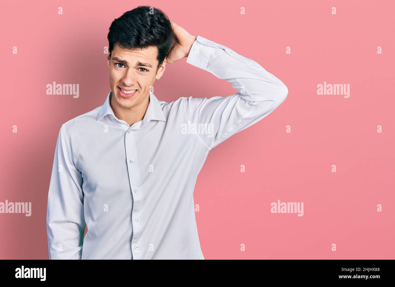 Young hispanic business man wearing business clothes confuse and wonder ...