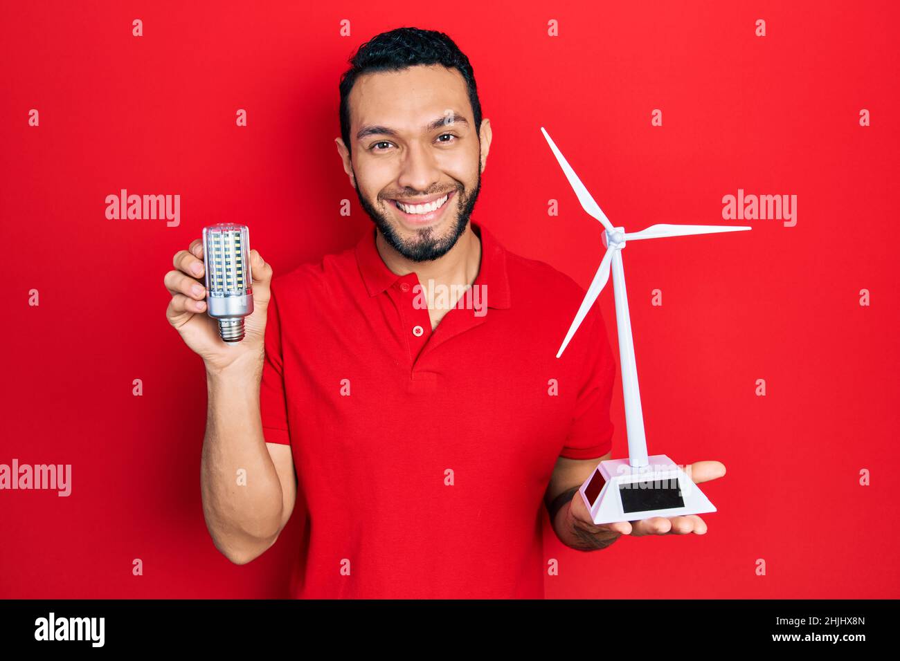Hispanic man with beard holding solar windmill for renewable ...