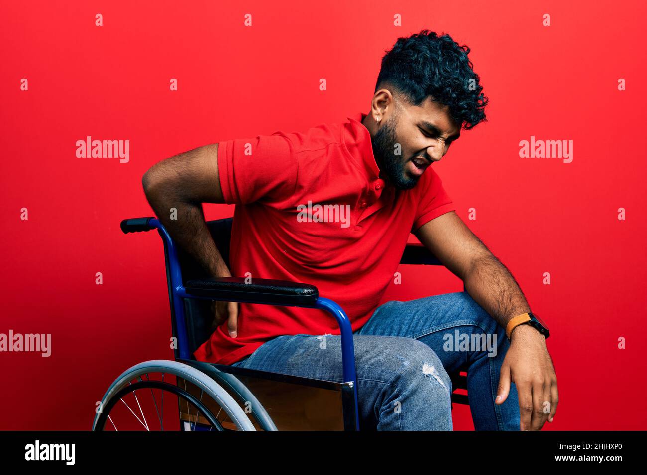 Arab man with beard sitting on wheelchair suffering of backache ...