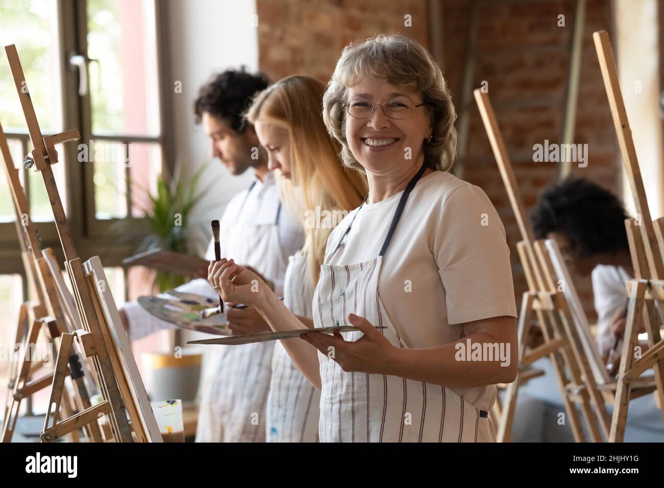 Happy senior retired student of art school drawing in class Stock Photo ...