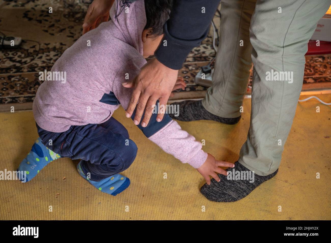after making a mistake a small child apologizes to his father with ...