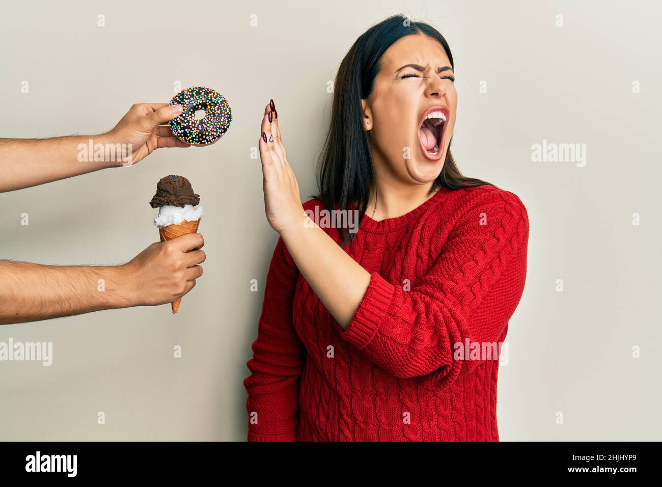 Beautiful brunette woman saying no to sweets on a healthy diet angry ...
