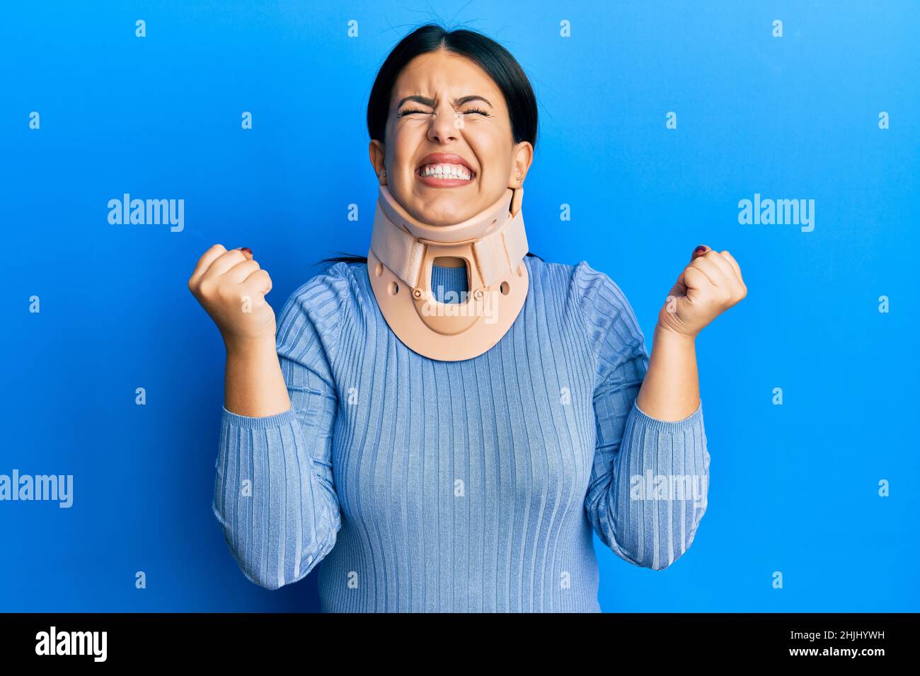 Beautiful brunette woman wearing cervical collar very happy and excited ...